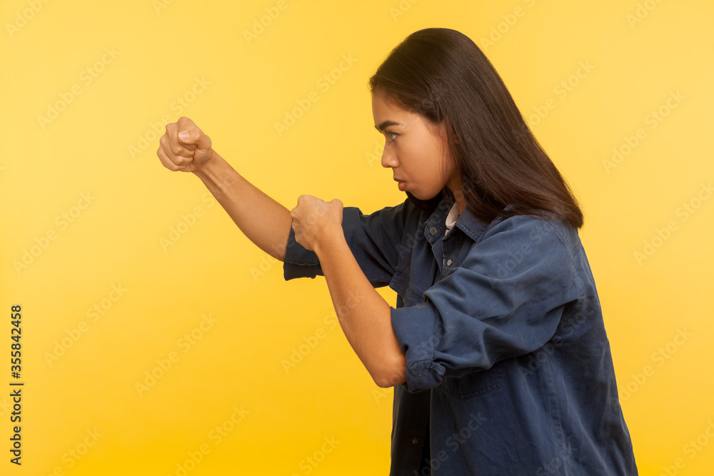 Let's fight! Side view of confident courageous girl in denim shirt ...