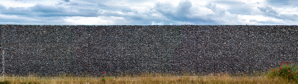 gabion wall made of metal grid filled with gravel Stock Photo | Adobe Stock