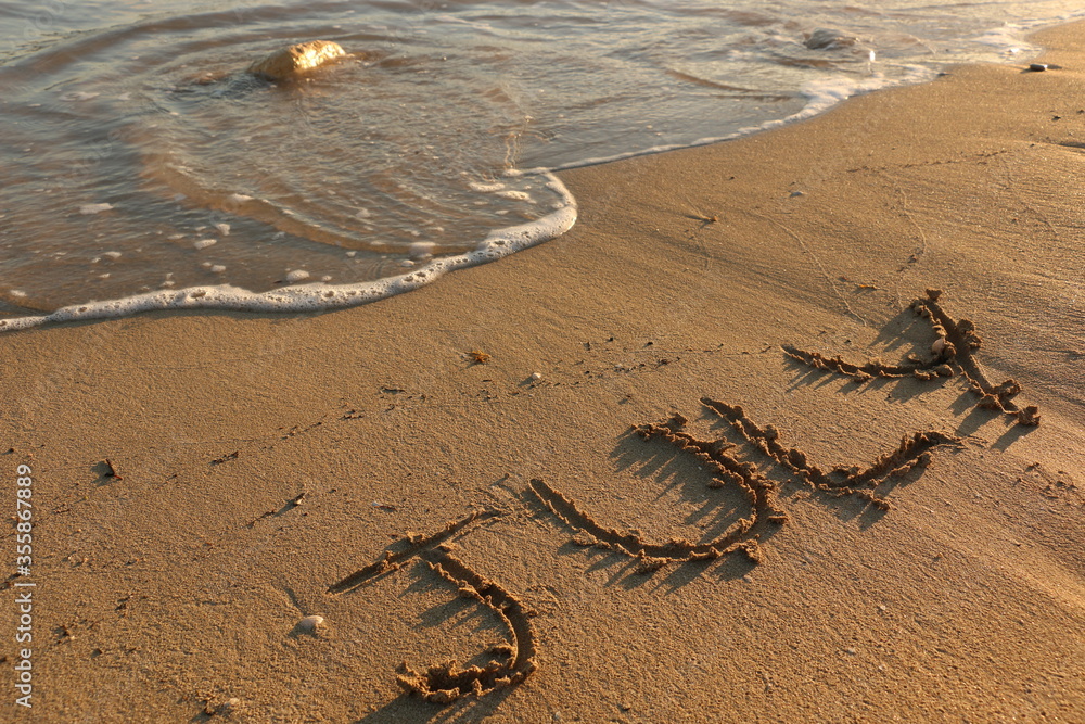 July Hand Written on Sandy Texture at a Sunny Beach with Pebbles with ...
