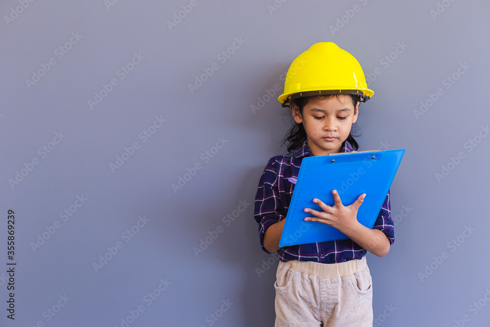 Asian little girl dress up engineering suit wearing helmet and holding ...