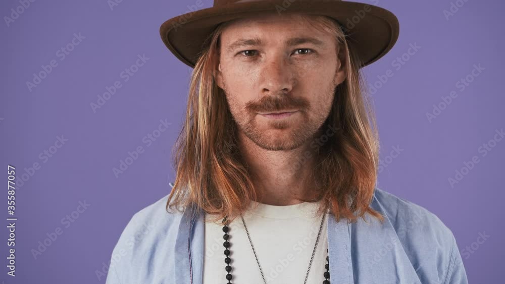 Elegant guy in casual outfit, hat and jewelry. He raising head, taking ...