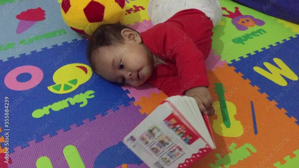 Adorable baby laying on floor trying to learn how to crawl. Happy baby ...