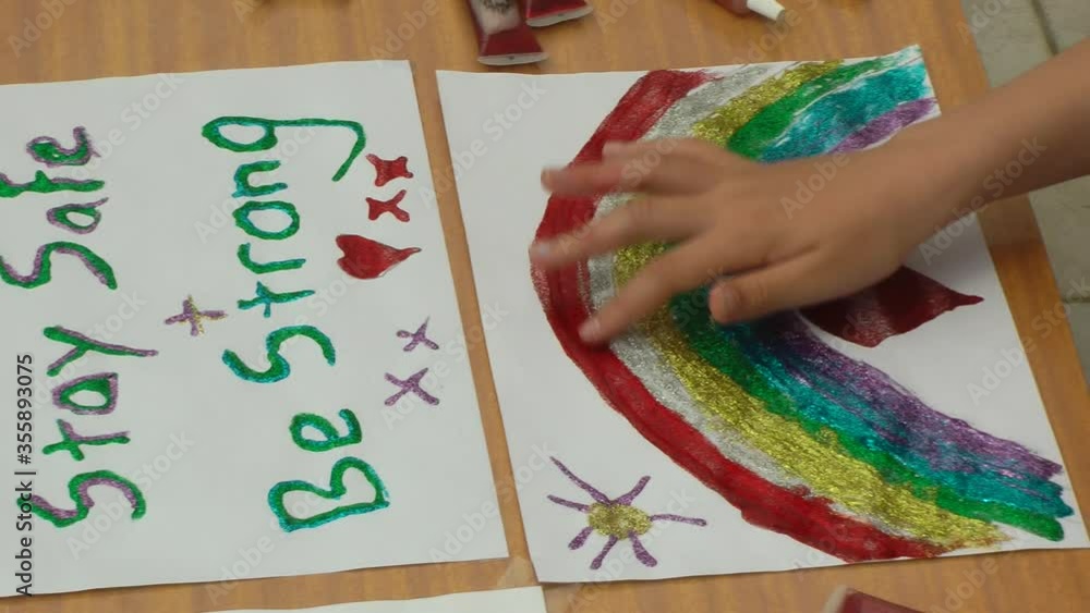 Child draws colorful glitter rainbow drawings for his house window ...