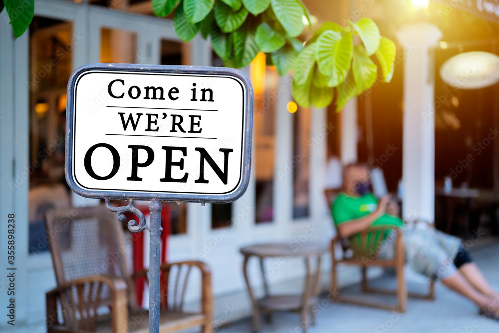 Closeup Metal signs placed in front of the shop is labeled Come on in ...