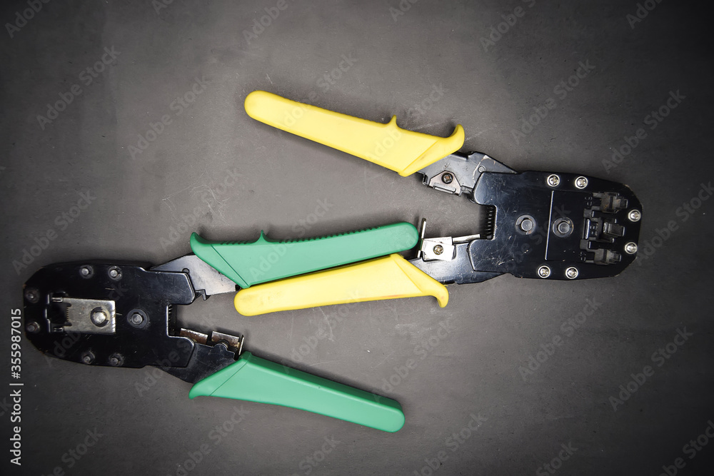 Yellow and green adjustable wire stripper isolated on a black ...