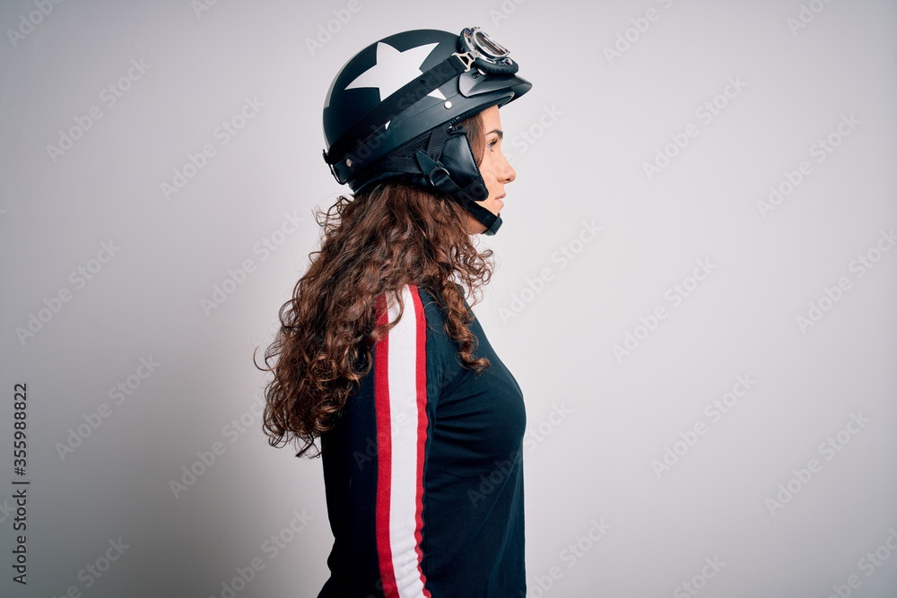 Beautiful motorcyclist woman with curly hair wearing moto helmet over ...