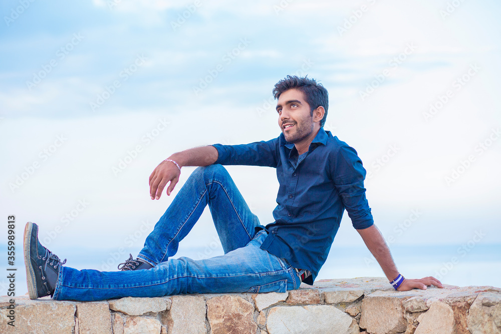 Man thinking sitting on a concrete bridge above the sea Stock Photo ...