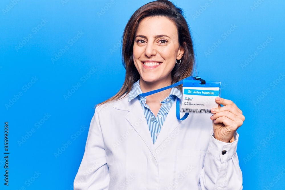 Young beautiful woman wearing doctor stethoscope holding id card ...
