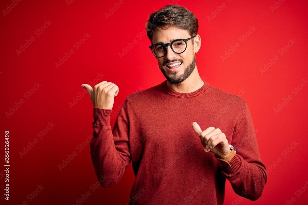 Young handsome man with beard wearing glasses and sweater standing over ...