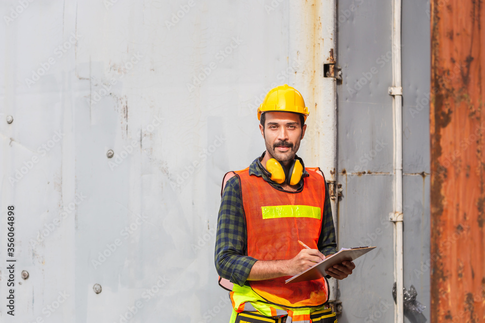 Worker man holding clipboard checklist and looking at camera checking ...