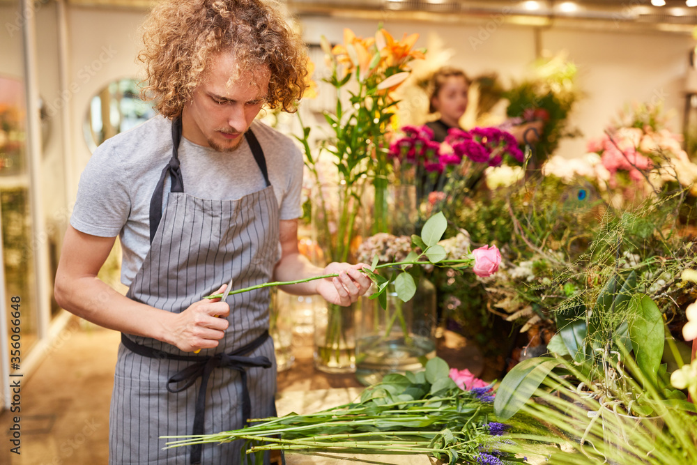 Florist or trainee tying flowers in the store Stock Photo | Adobe Stock