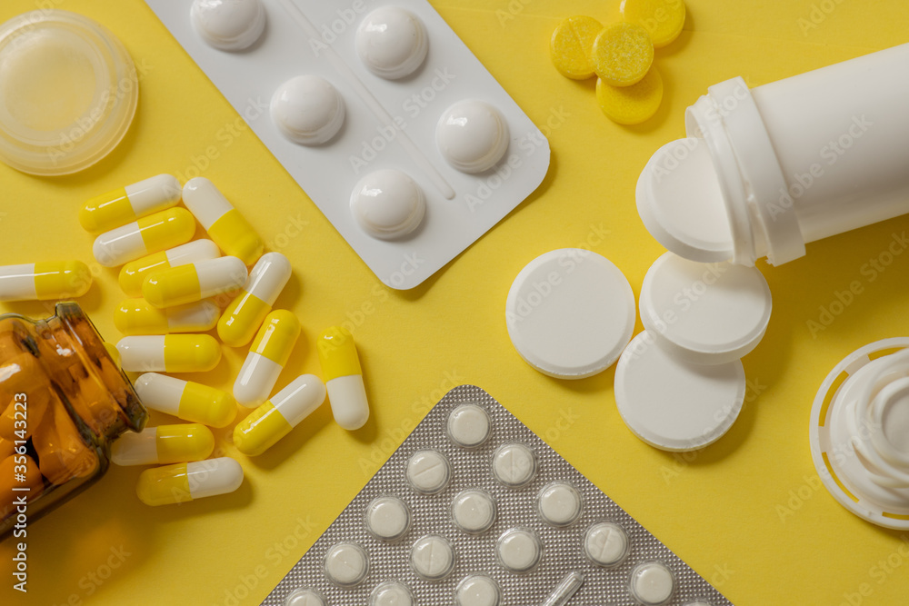 medicines and tablets on a yellow background, capsules, soluble ...