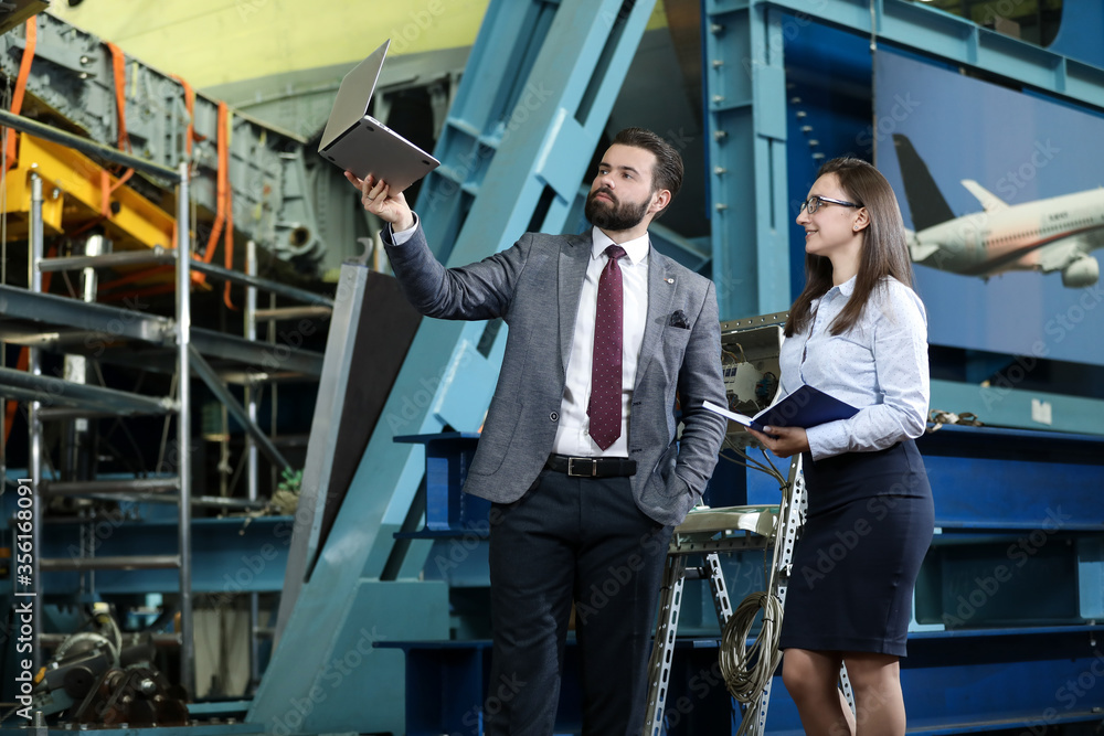 Portrait of a solid businessman with his secretary holding blue ...