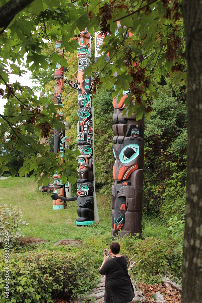 Aboriginal / Native American tall wooden totem poles, aligned in a row ...