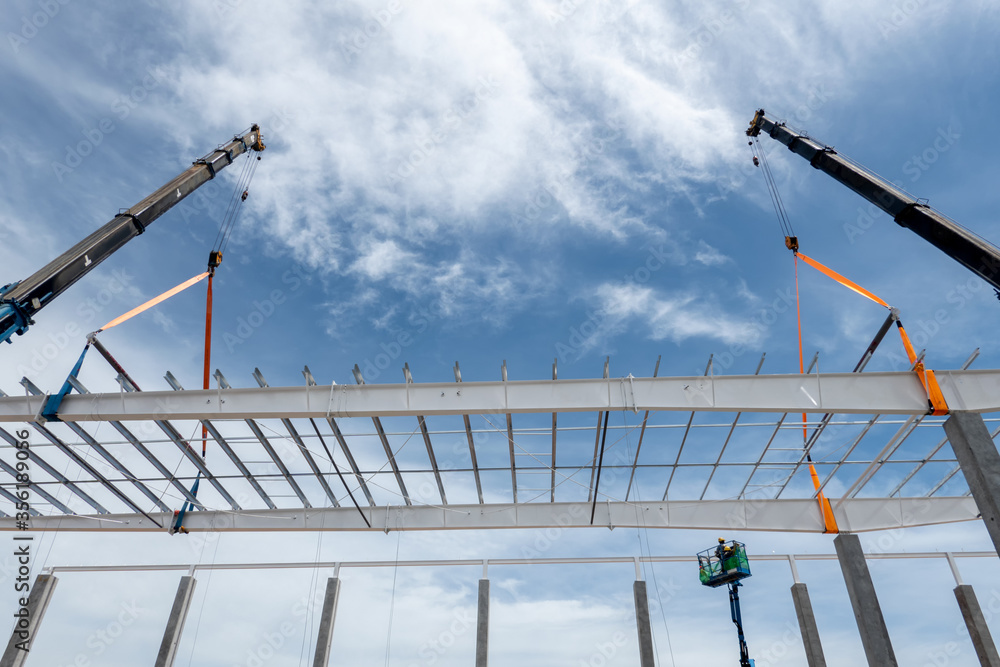 Construction worker working at boom lift installation steel roof beam ...