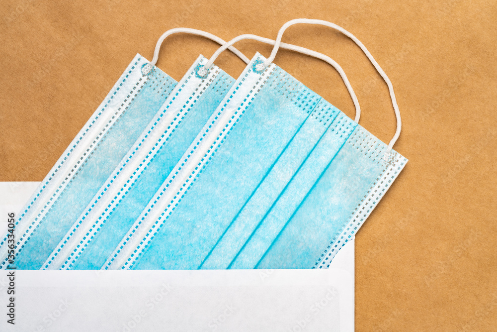 Blue medical surgical face masks in white postal envelope on yellow ...