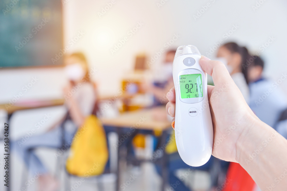 Digital thermometer, thermometer gun on teacher hand using for check ...