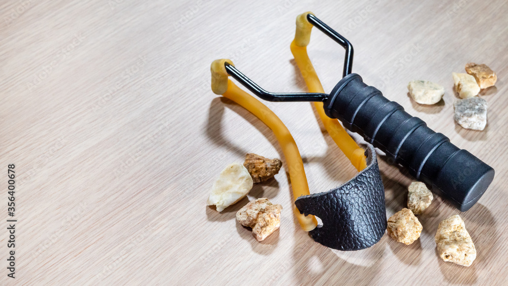 Stone and rock with slingshot small hand-powered projectile weapon ...