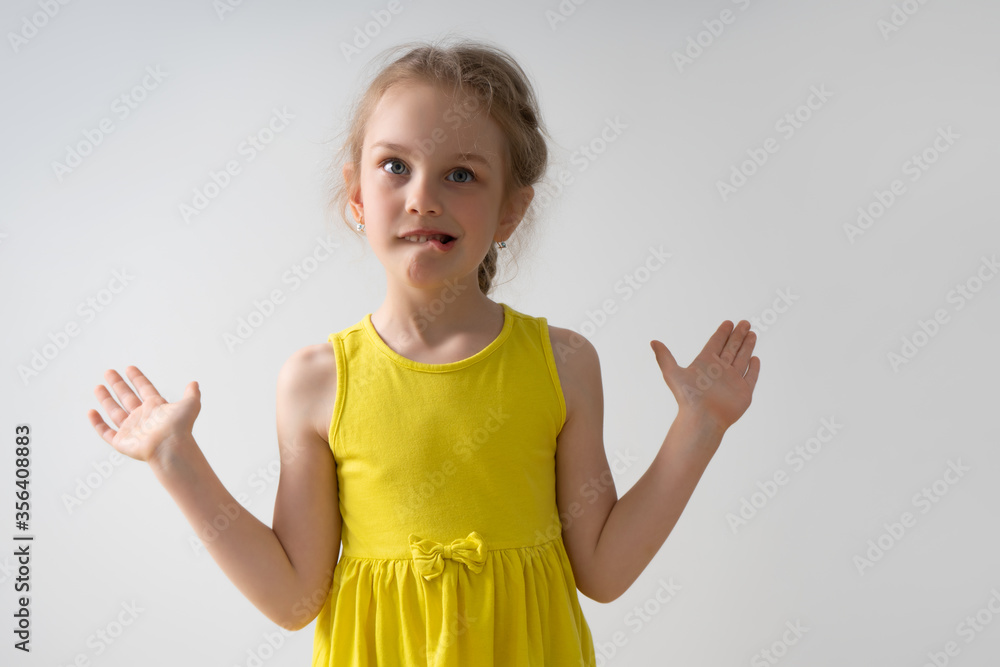 Anxious little girl throwing up her hands in a helpless gesture and ...