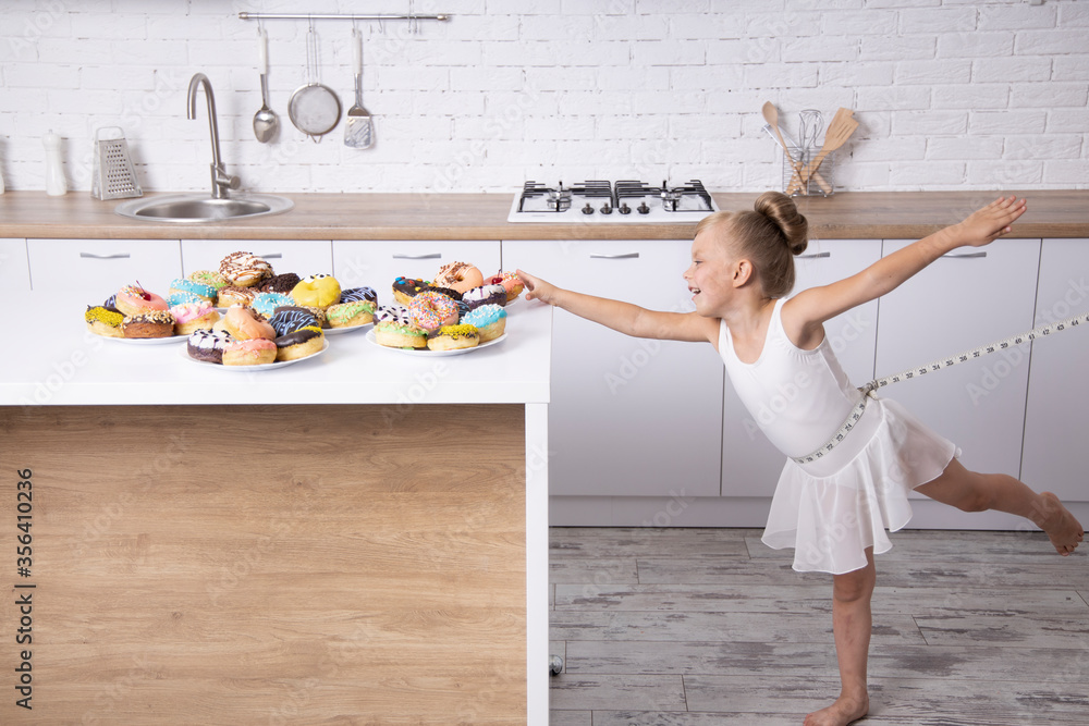 Little girl reaches for donuts. Little girl wants donuts. Little girl ...