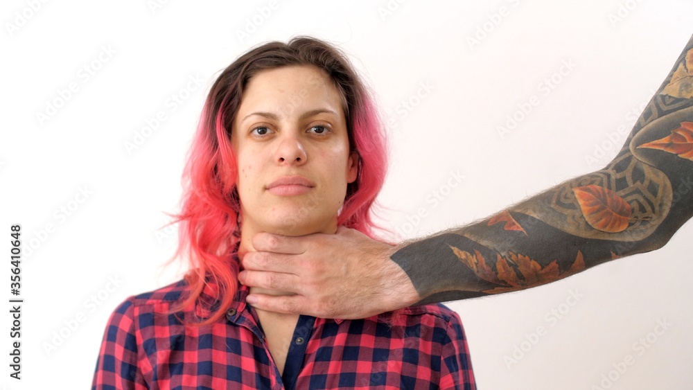 Portrait of a frightened woman over white background. Male hand in ...