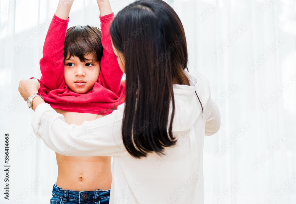 Asian happy beautiful mother getting dressed clothes on her kids son ...