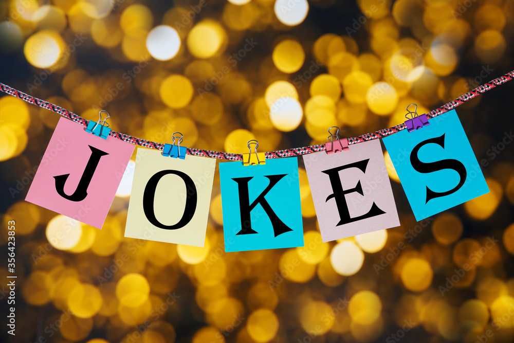 Word JOKES printed on clothespin clipped cards in front of defocused ...