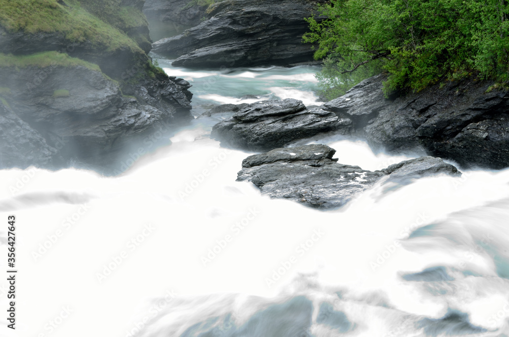 milky white massive long waterfall down slippery valley rocks and ...