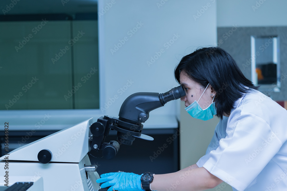 Asian Scientists are using a microscope to view the structure of a ...