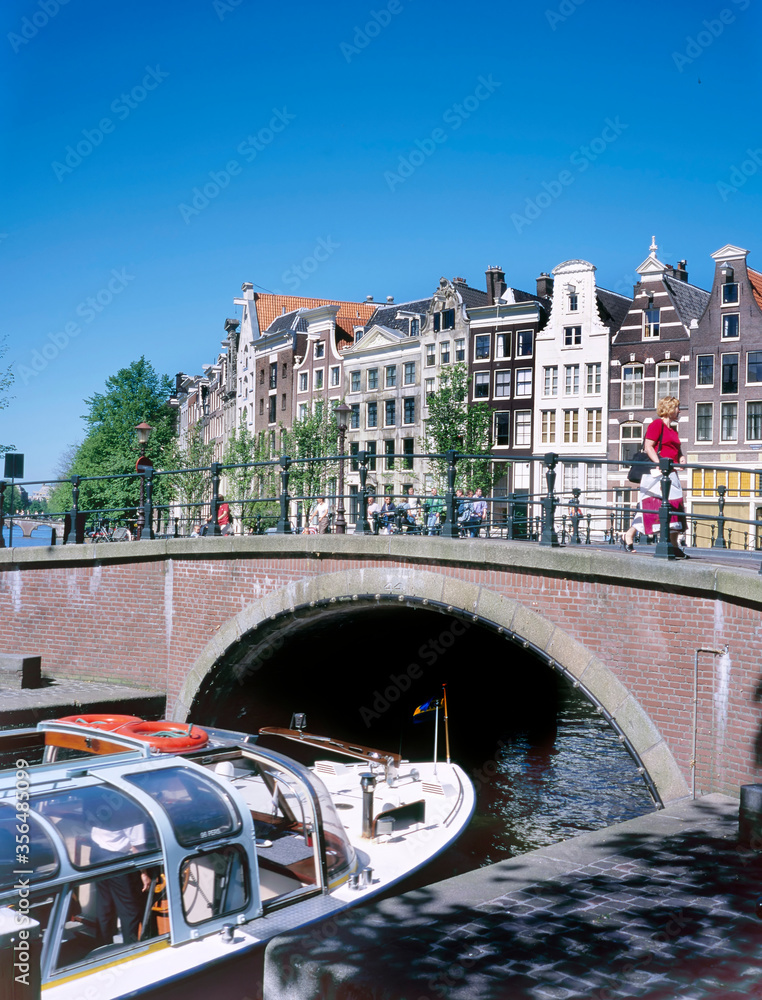 Amsterdam canal boat going under the bridges of a canal Stock Photo ...