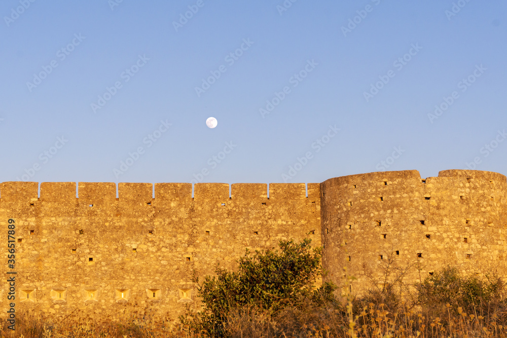 Medieval castle wall with arrow loops and battlements and fool moon ...