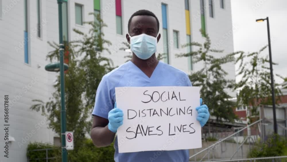 African American black male nurse doctor in medical PPE with sign ...