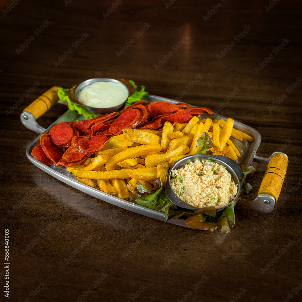 Porção de batata frita com calabresa frita foto de Stock | Adobe Stock