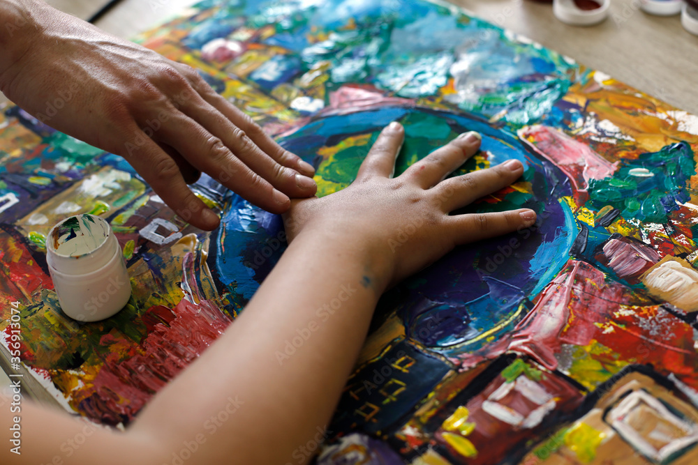 Drawing lesson. A teacher helps a child during a drawing lesson. Finger ...
