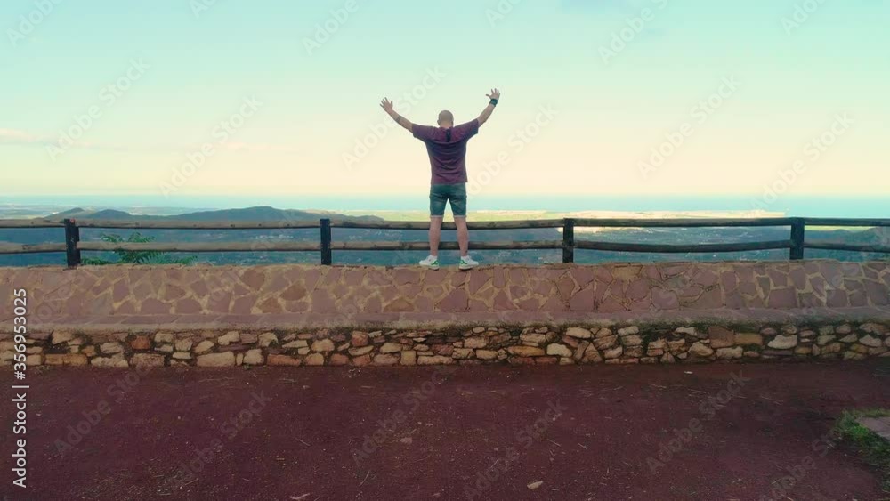 vuelo por la espalda de dron sobrevolando persona asomada a barranco ...