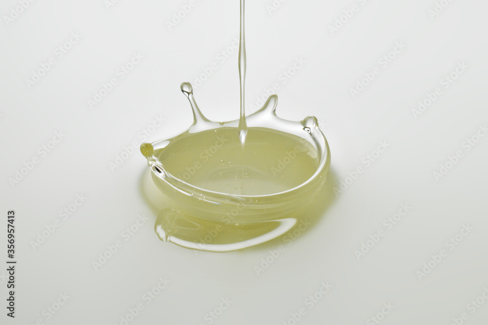 Dripping colorless oil on white background. Stock Photo | Adobe Stock