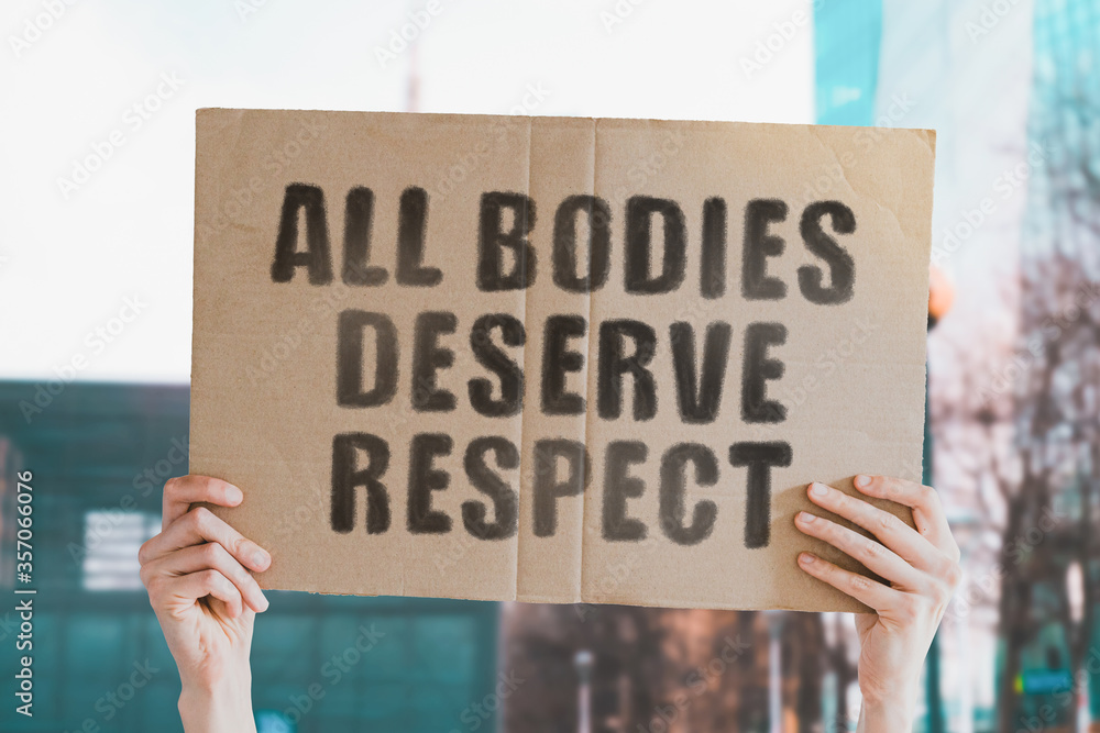 The phrase " All bodies deserve respect " on a banner in men's hand ...