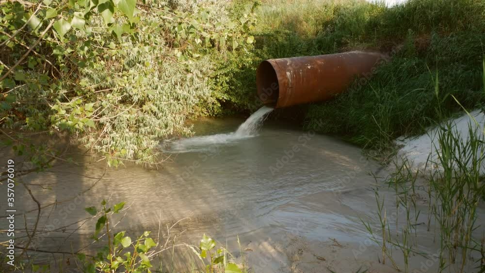 drain pipe. Water flows from a large metal pipe. Sand pit drainage ...