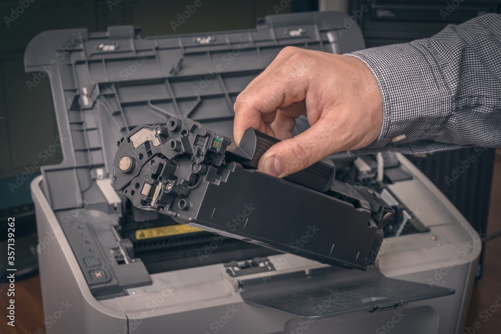Man is replacing black cartridge in a printer Stock Photo | Adobe Stock