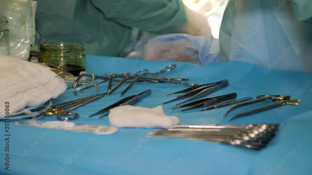 Nurse assisting doctors surgeons during surgical procedure in operating ...