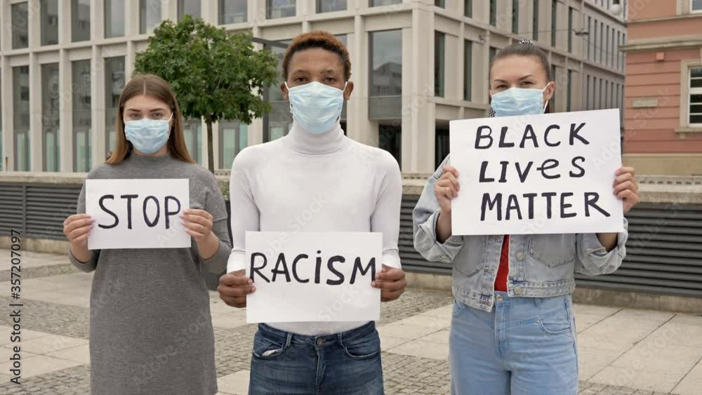 Three young people of different nationalities protest against racial ...