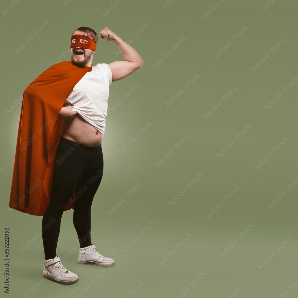 Body positive Super hero man shows his muscles and tummy. Super power ...