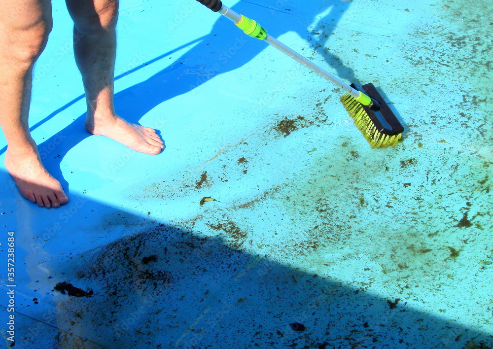 Cleaning the dirty empty pool of algae, water stone and limescale. The ...
