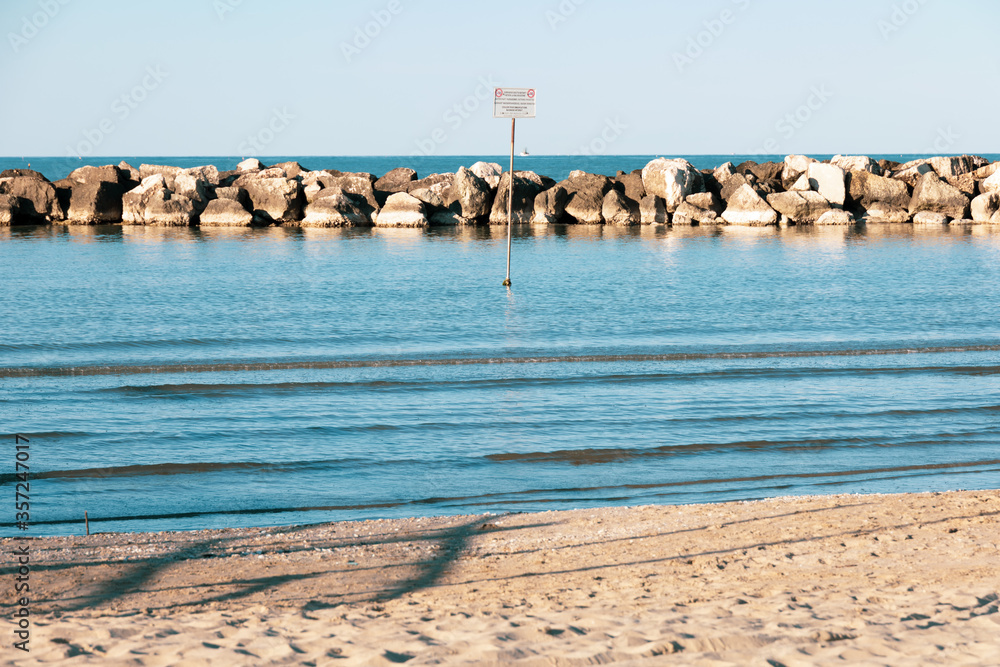A sign in the sea warning about swimming rules in one of the most ...