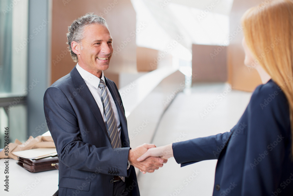 Smiling businessman shaking hands with businesswoman Stock Photo ...