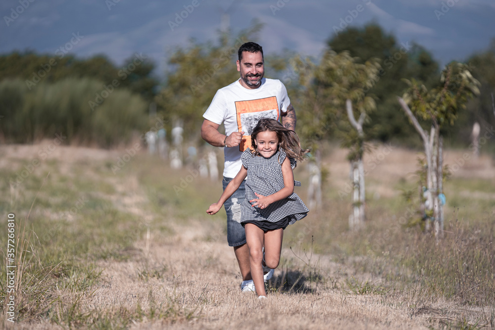 Father running behind his little daughter Stock Photo | Adobe Stock