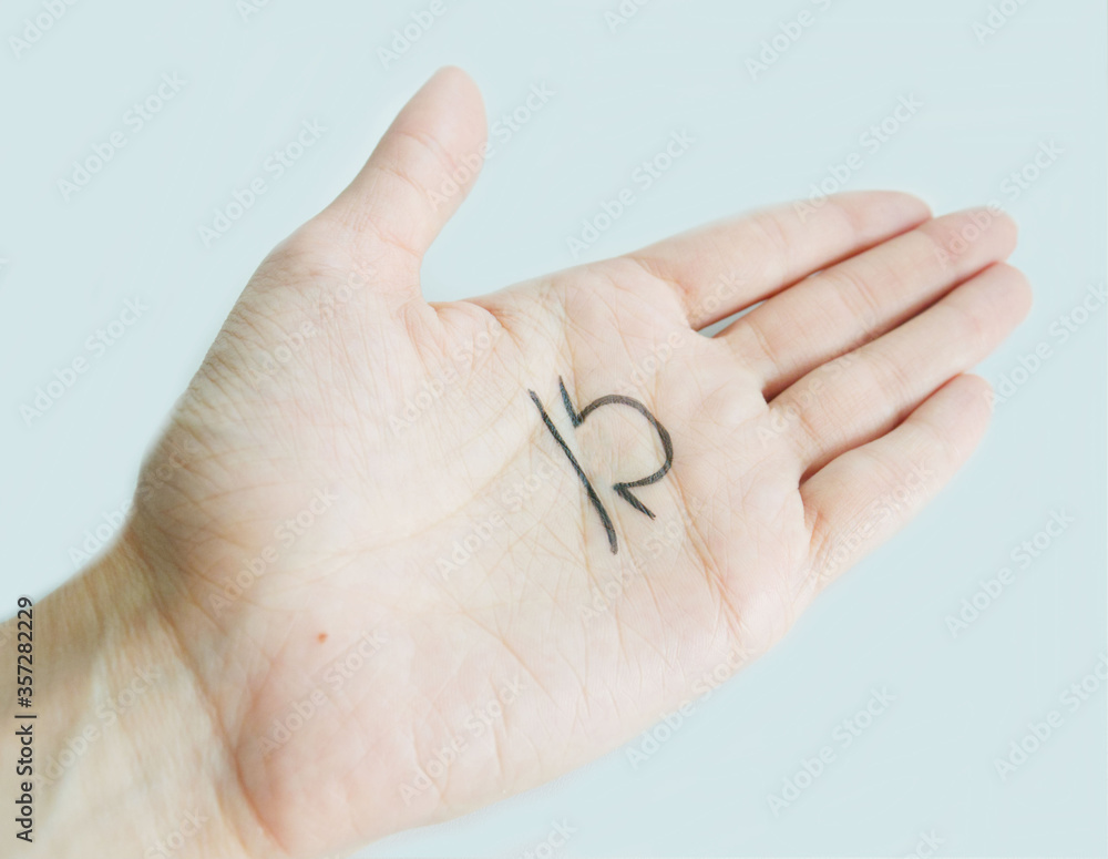 On the palm of a young girl, top view, with a black felt-tip pen is ...