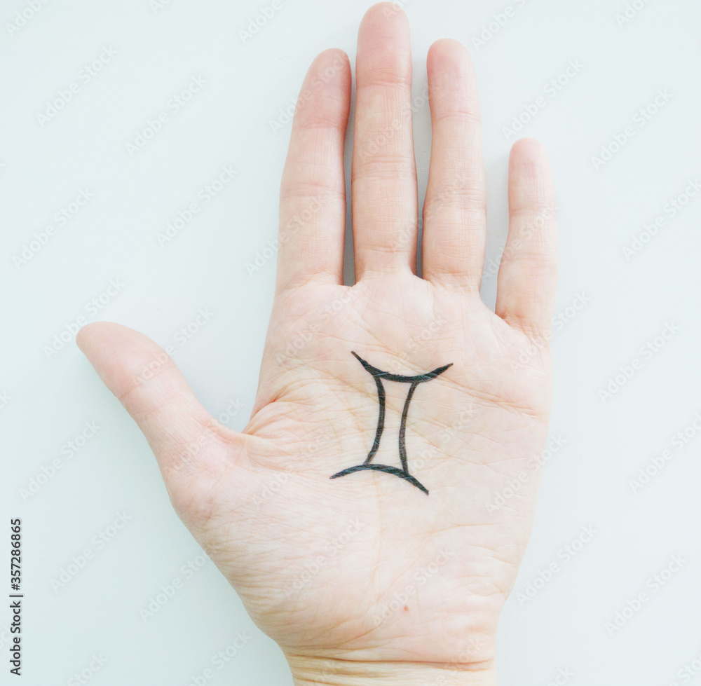 Palm of a young girl, top view, with a black felt-tip pen drawn, zodiac ...