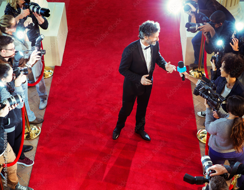 Celebrity on red carpet being interviewed photographed by paparazzi ...
