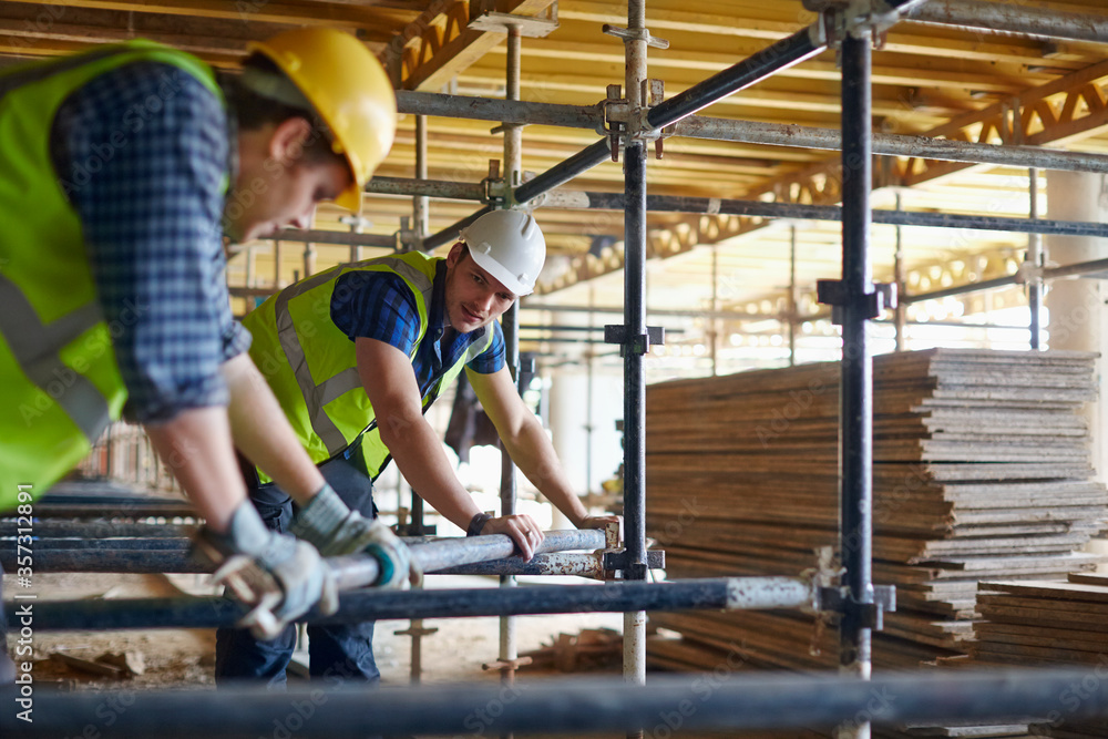 Construction workers adjusting metal bar at construction site Stock ...